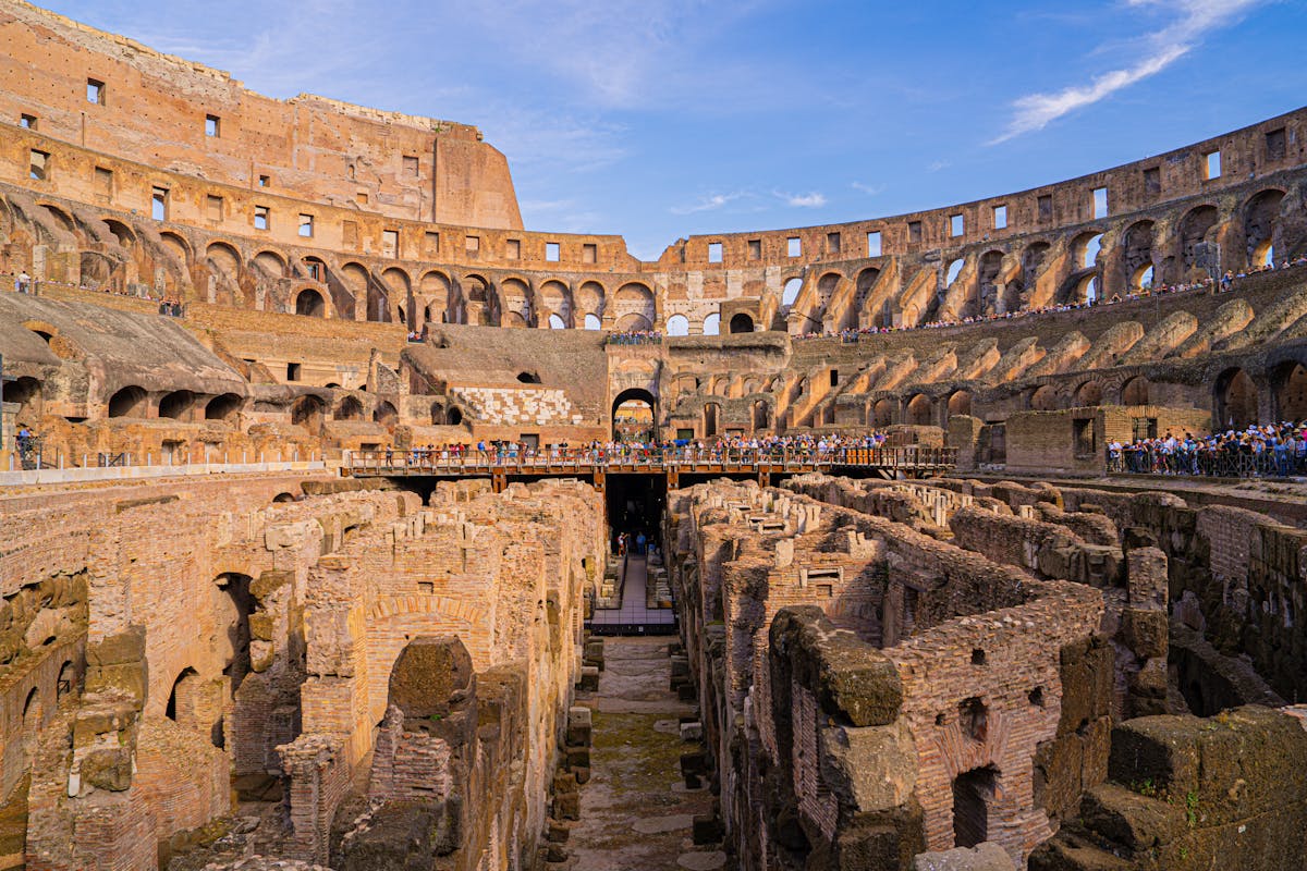 Interior of the Colosseum arena in Rome showing exposed underground chambers and tiered seating