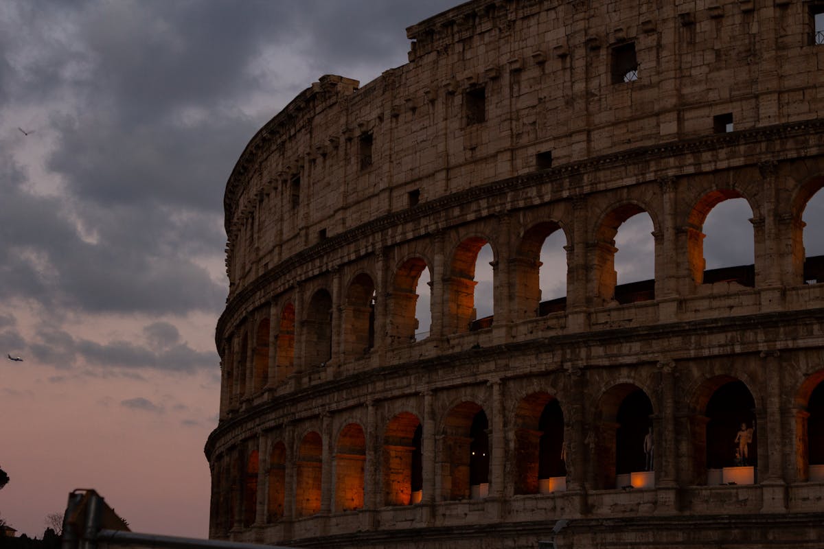 The Colosseum at dusk with a dramatic orange and purple sky