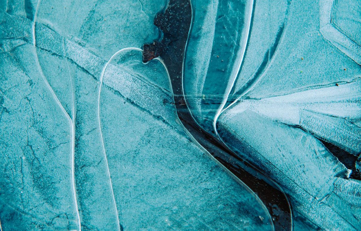 Close-up of blue ice with intricate cracks and texture