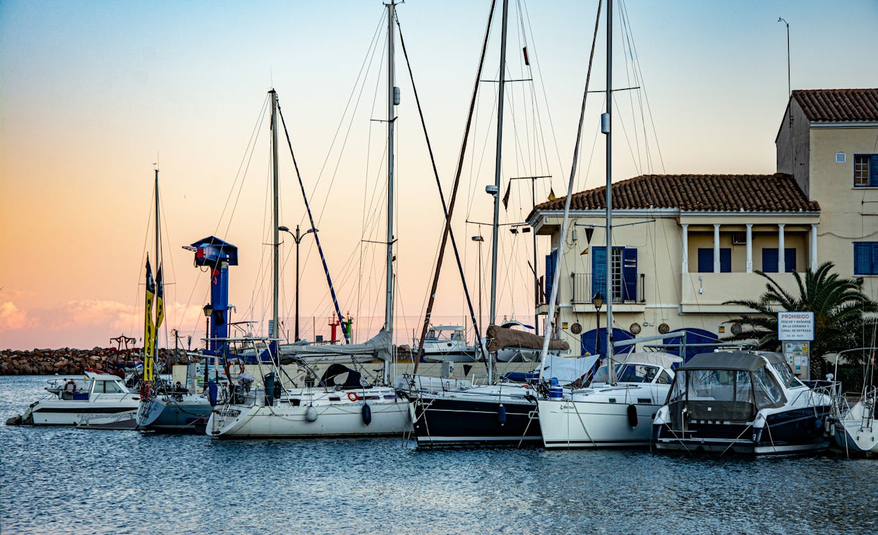 Boats docked at Port Saplaya harbor with a soft sunset glow in Valencia Spain