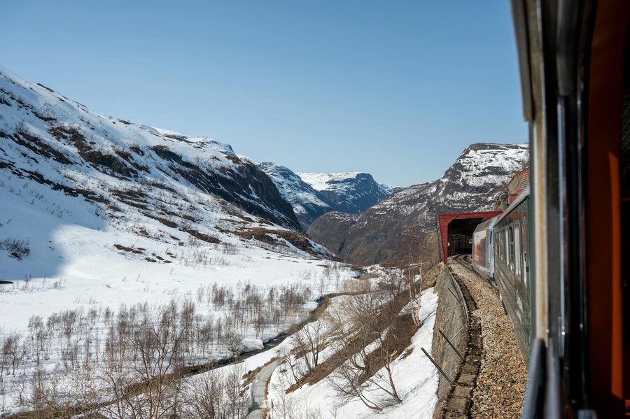 Experience an unforgettable train ride through snow-covered landscapes and majestic fjords in Flåm, 