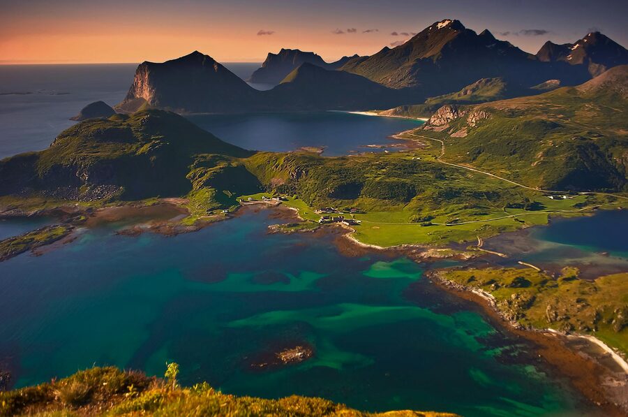Beautiful aerial landscape of Lofoten Islands, Norway during sunset, showcasing mountains and ocean.