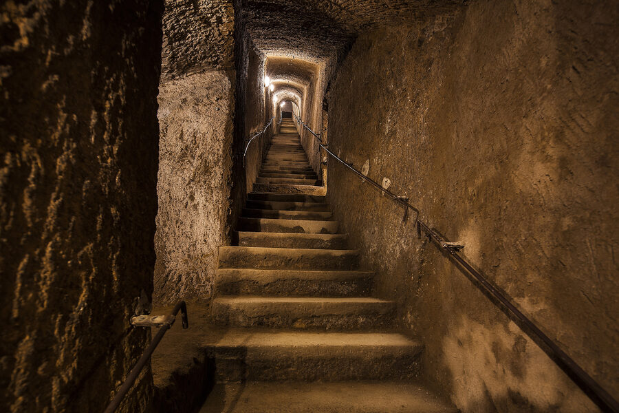Stone staircase leading down into the underground passages of the Bourbon Tunnel in Naples