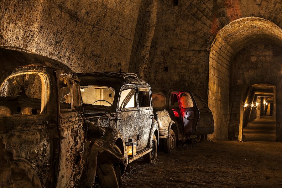 Abandoned vintage cars including Fiat 500s stored inside the Bourbon Tunnel where police dumped confiscated vehicles after WWII