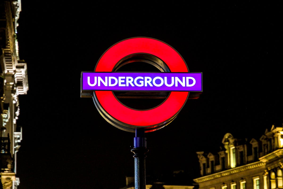 Vibrant London Underground sign illuminated at night showcasing urban navigation