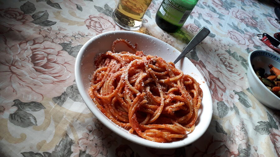 Plate of bucatini all amatriciana with tomato sauce and pecorino cheese in Rome
