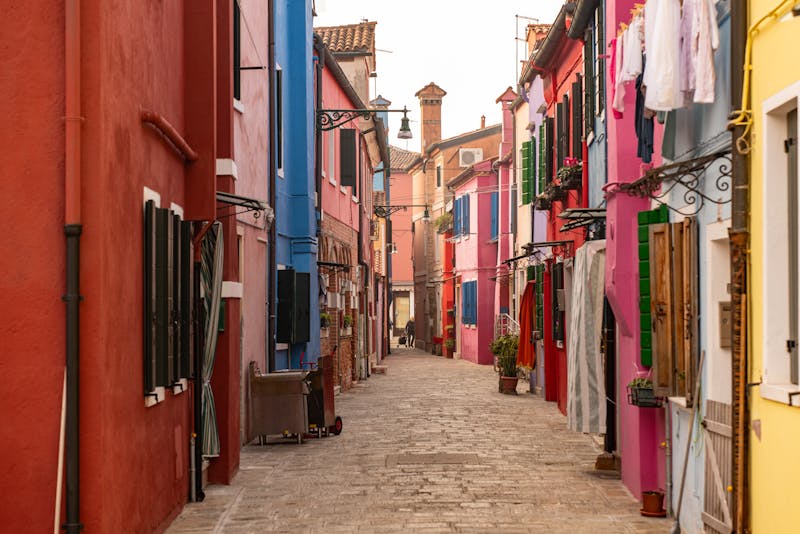 A colorful street in Burano, Venice, Italy, with painted houses and traditional architecture