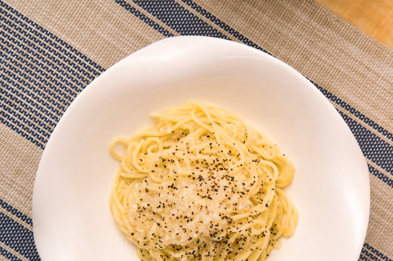 A plate of Italian spaghetti with cheese and black pepper