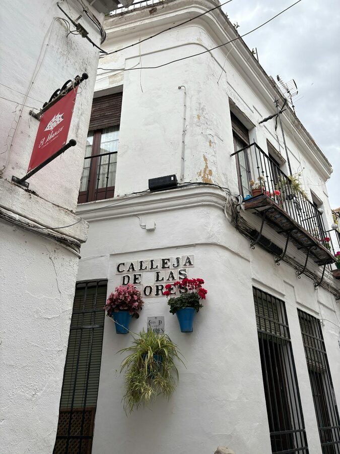 The famous Calleja de las Flores narrow alley in Cordoba with the bell tower visible