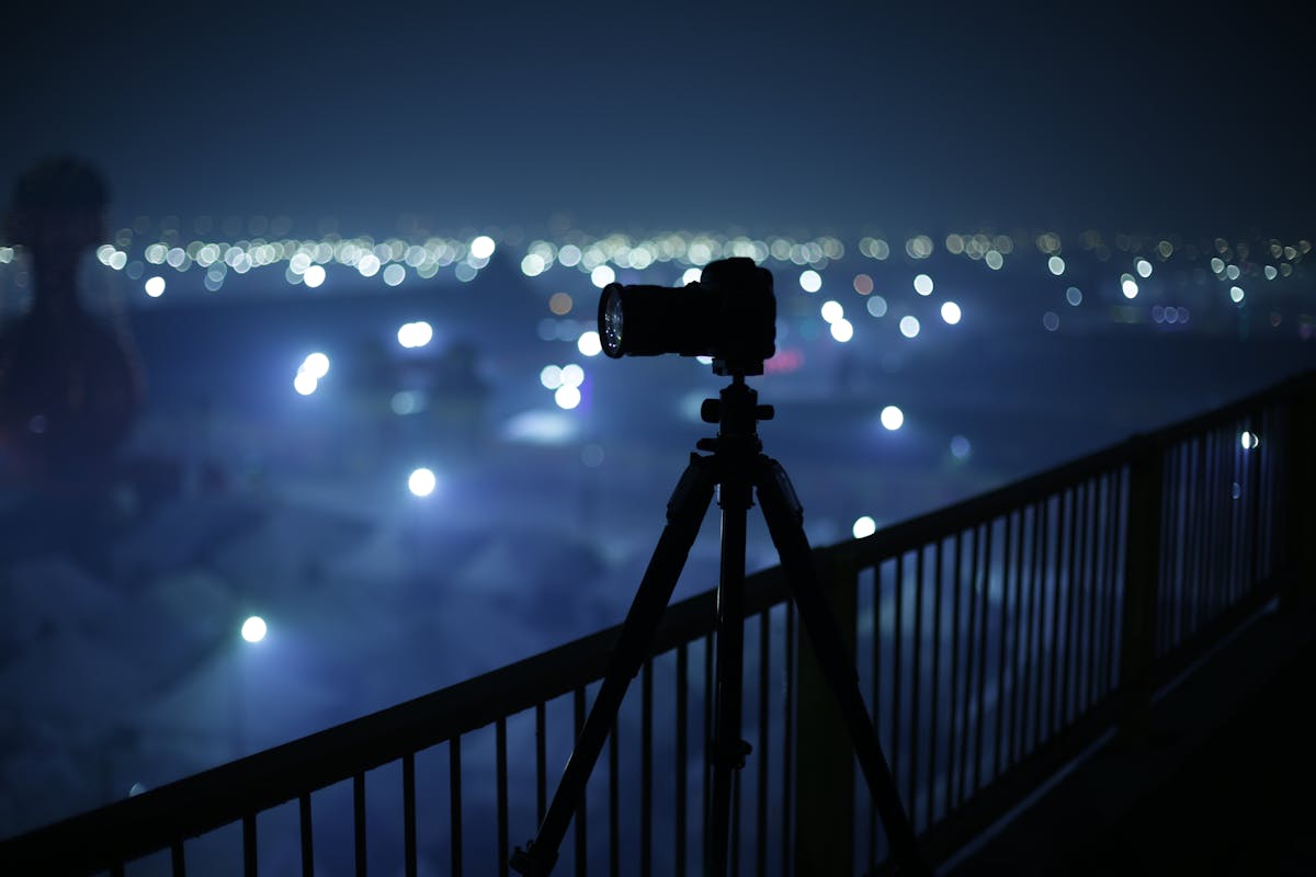 Camera on tripod set up for night photography at a festival with long exposure