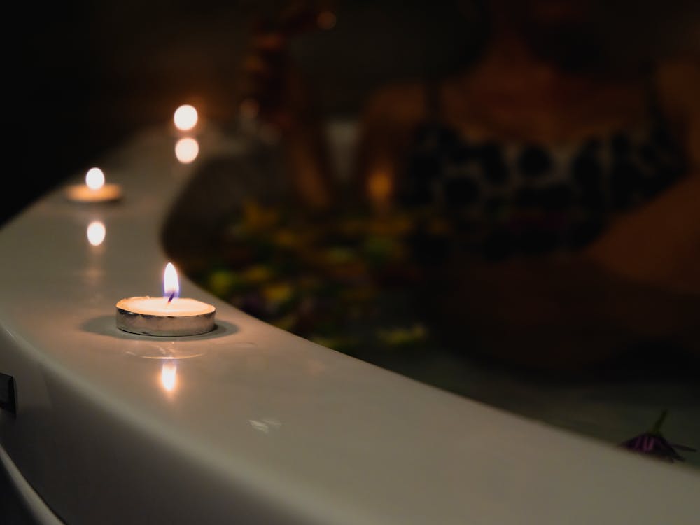 Lit candles beside a thermal bath creating a soothing atmosphere