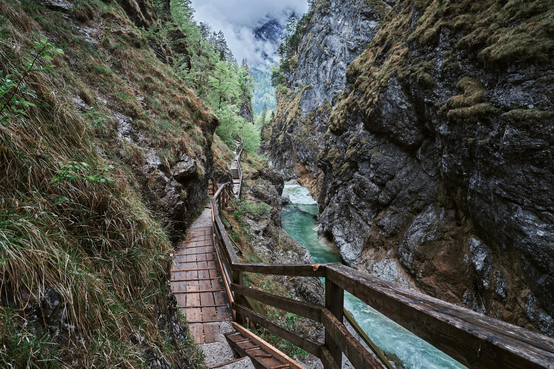Alpine gorge with wooden walkway trail alongside rushing water