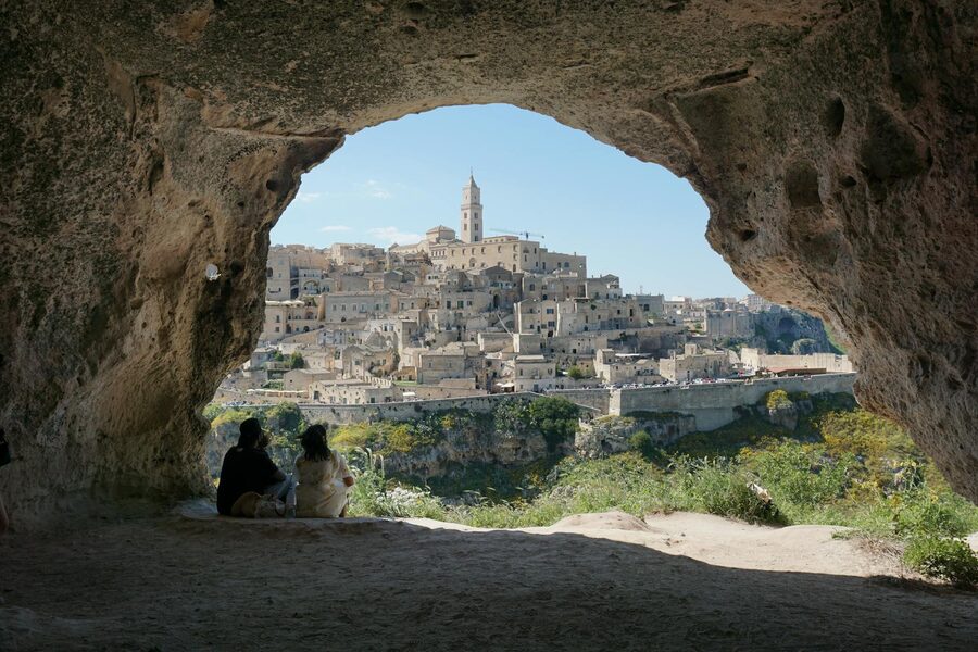 Narrow stone street winding through the Sassi di Matera with cave dwellings on both sides