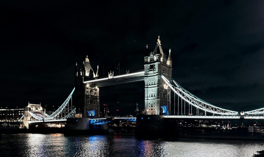 Tower Bridge illuminated at night reflecting on the Thames