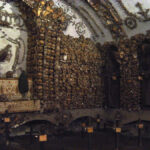 Interior of the Capuchin Crypt in Rome showing bones of monks arranged decoratively on walls and ceiling