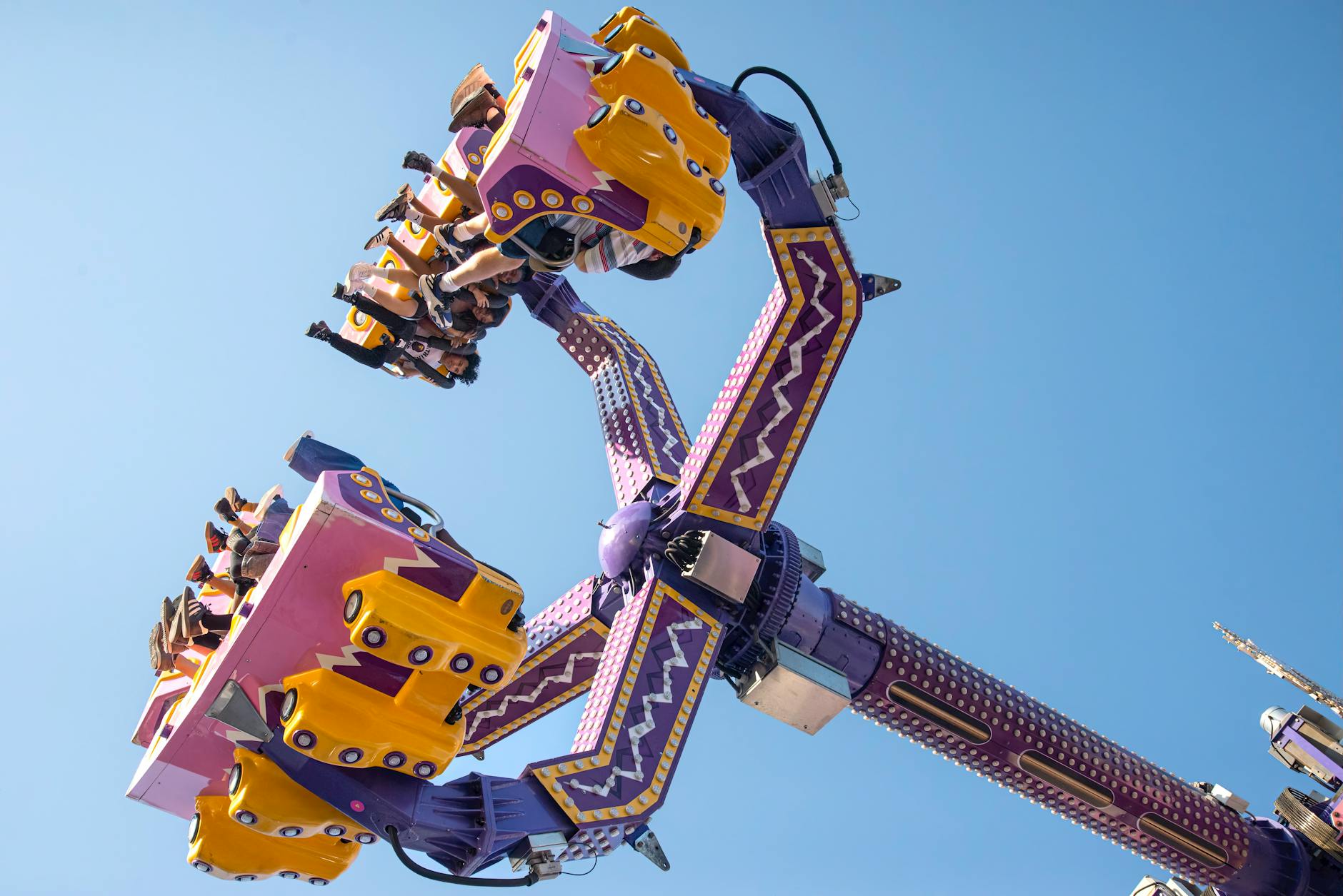 Carnival ride with people enjoying a sunny day