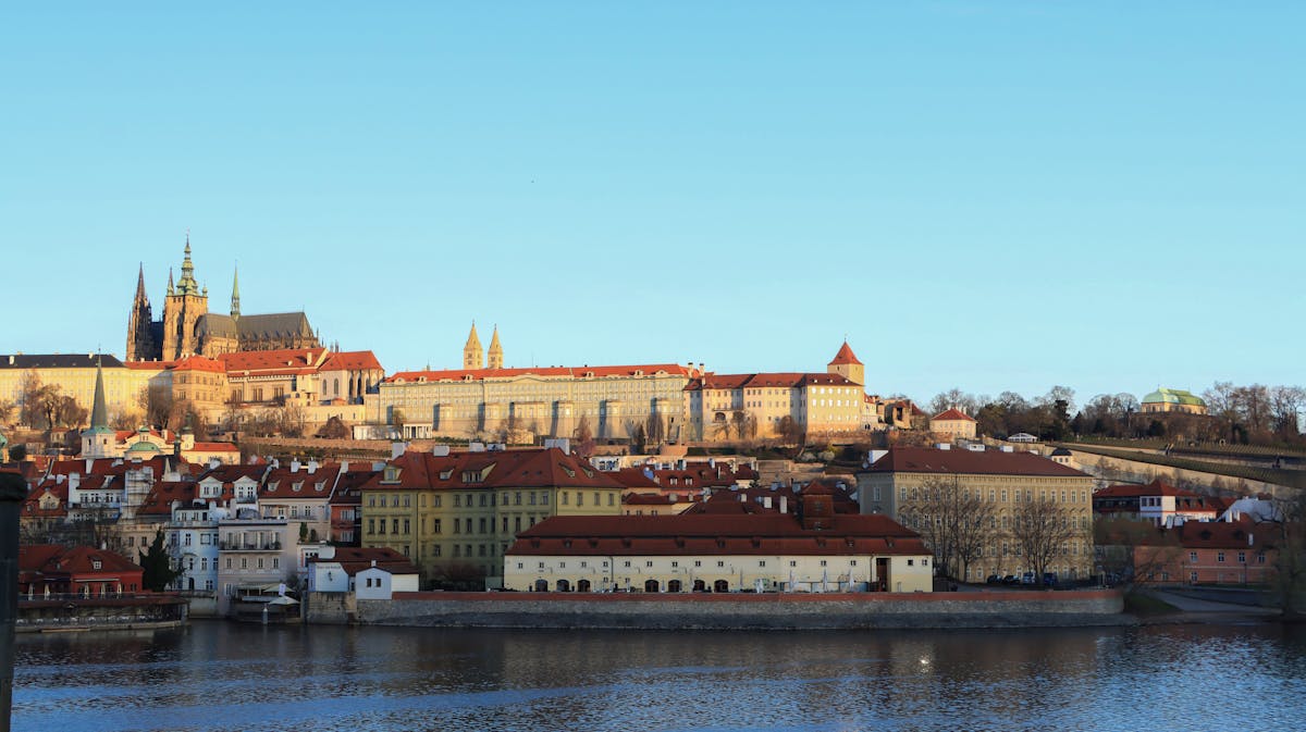 Prague Castle on the hill above the Vltava River in summer sunlight