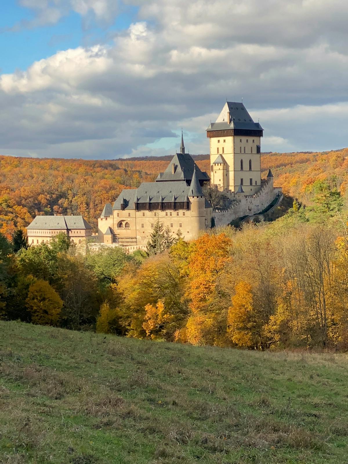 Scenic autumn landscape with Karlstejn Castle surrounded by colorful foliage