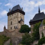 Medieval Karlstejn Castle surrounded by lush green forest on a hill