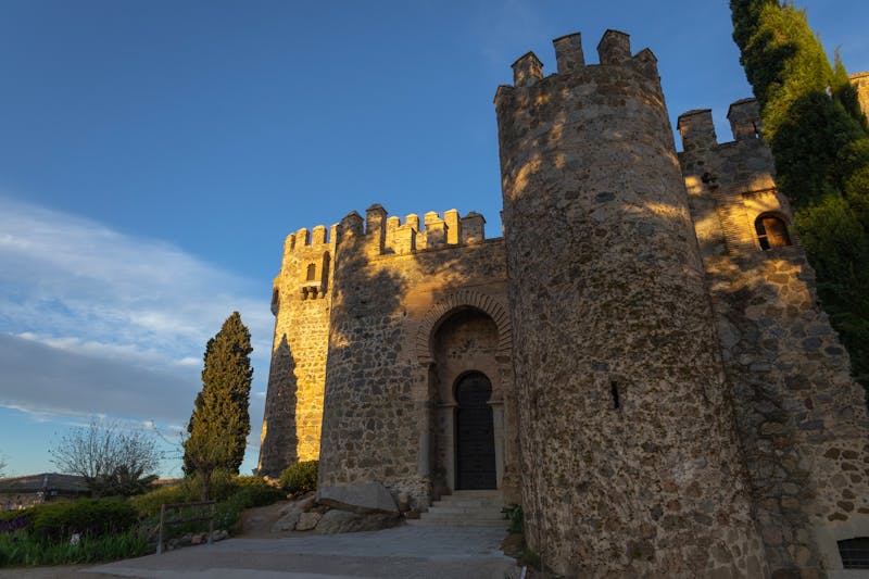 Stone castle walls in Toledo Spain bathed in warm golden sunset light