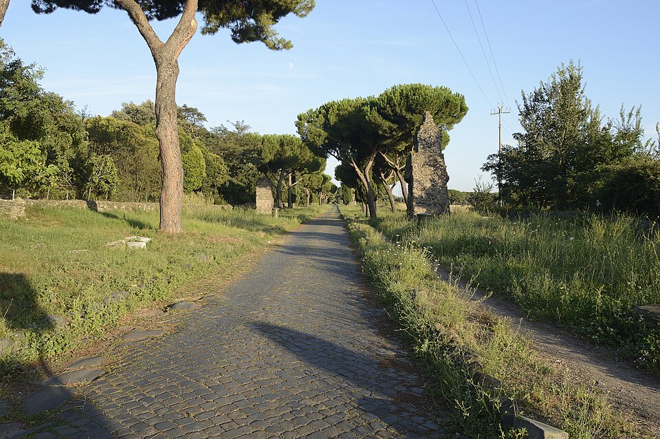 The Appian Way near Rome showing original Roman stone pavement lined with trees and ancient tombs