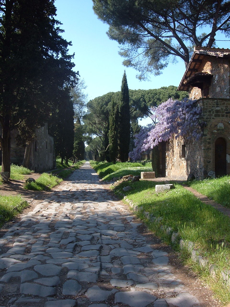 The ancient Via Appia road in Rome with original stone pavement and ruins alongside