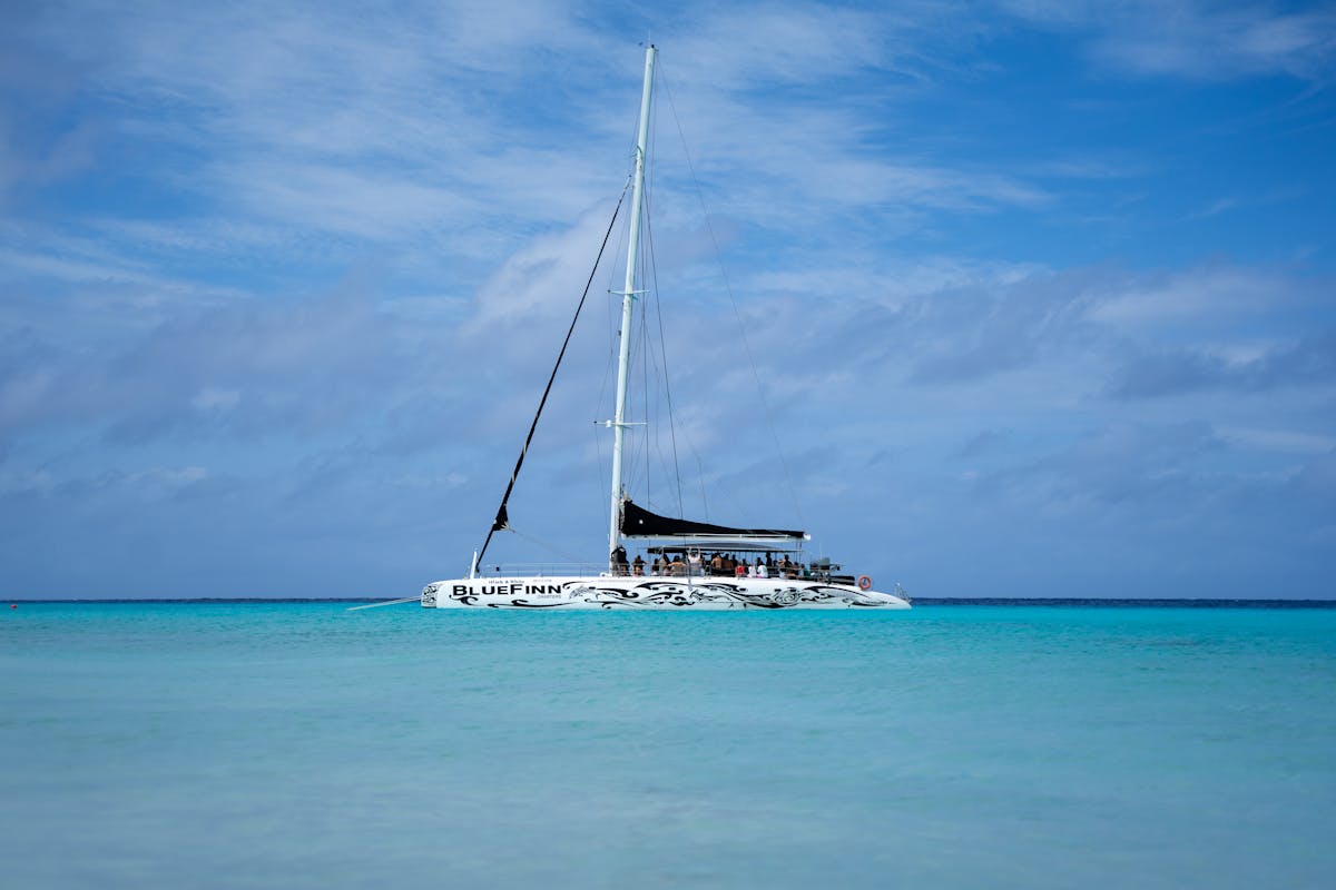 Catamaran sailing on clear turquoise waters under a bright sky