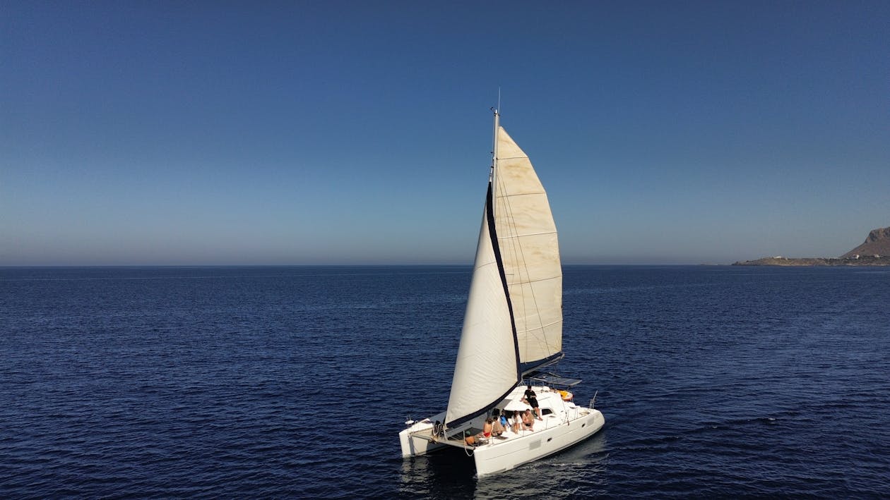 A sailing catamaran gliding on the open sea under a clear sky