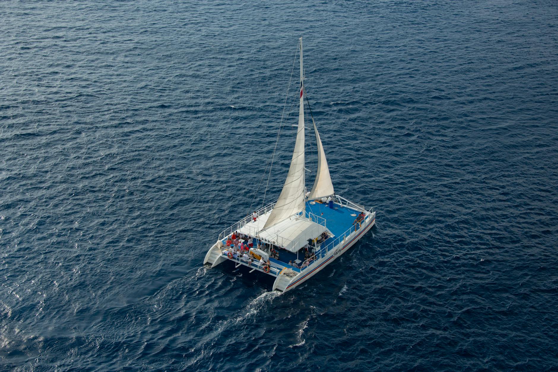 Catamaran with passengers sailing on clear blue Mediterranean waters