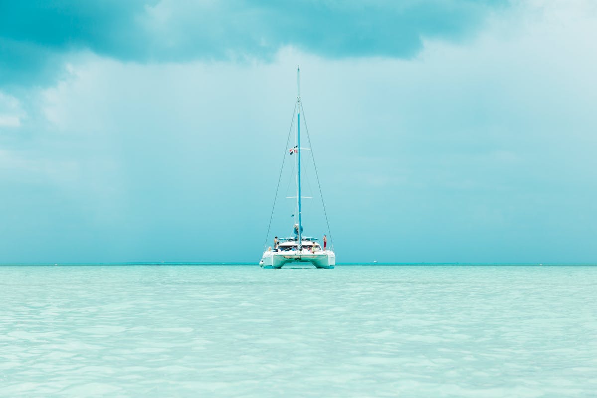 Catamaran with passengers sailing in turquoise waters
