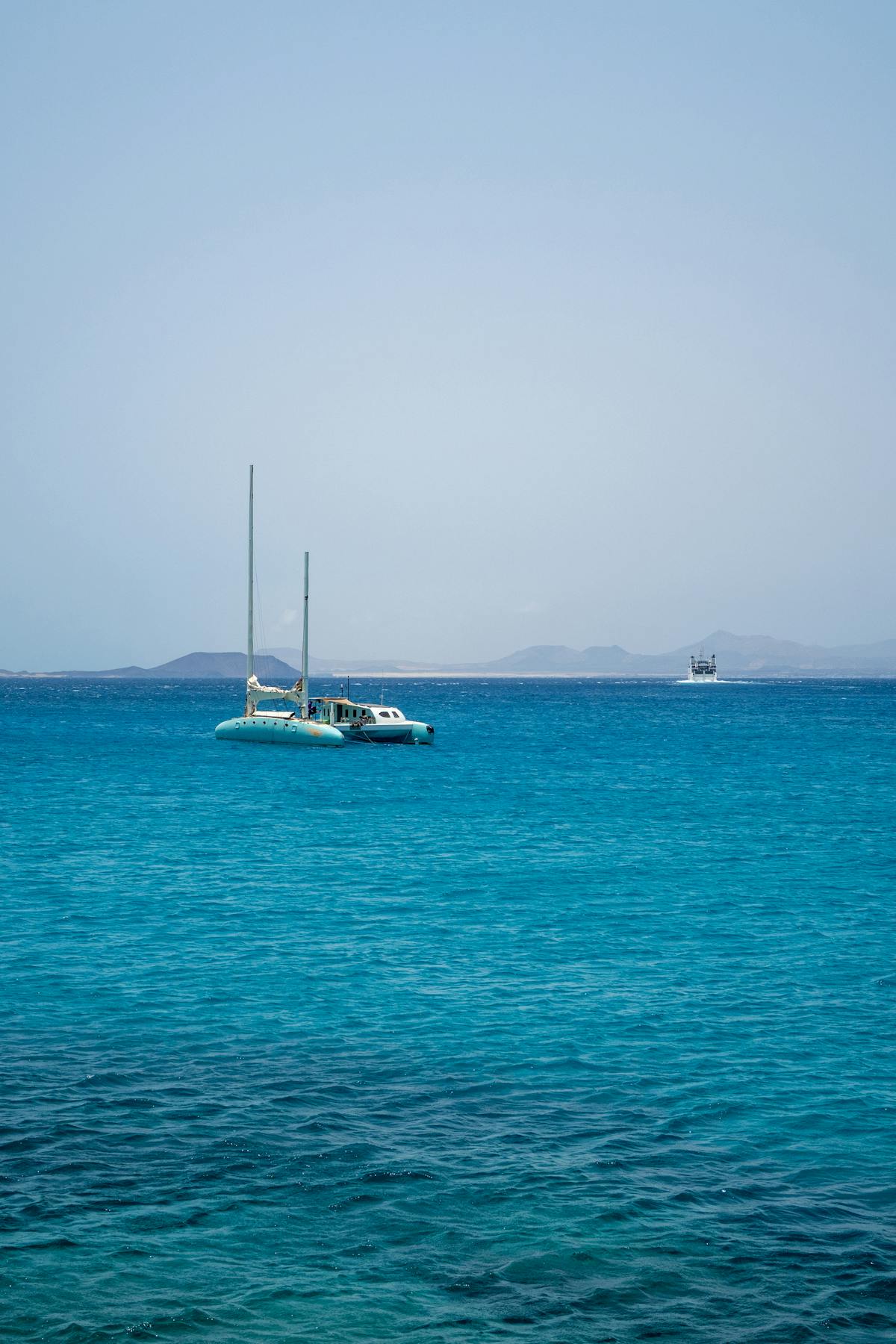 Catamaran anchored on turquoise sea near the coast of Spain