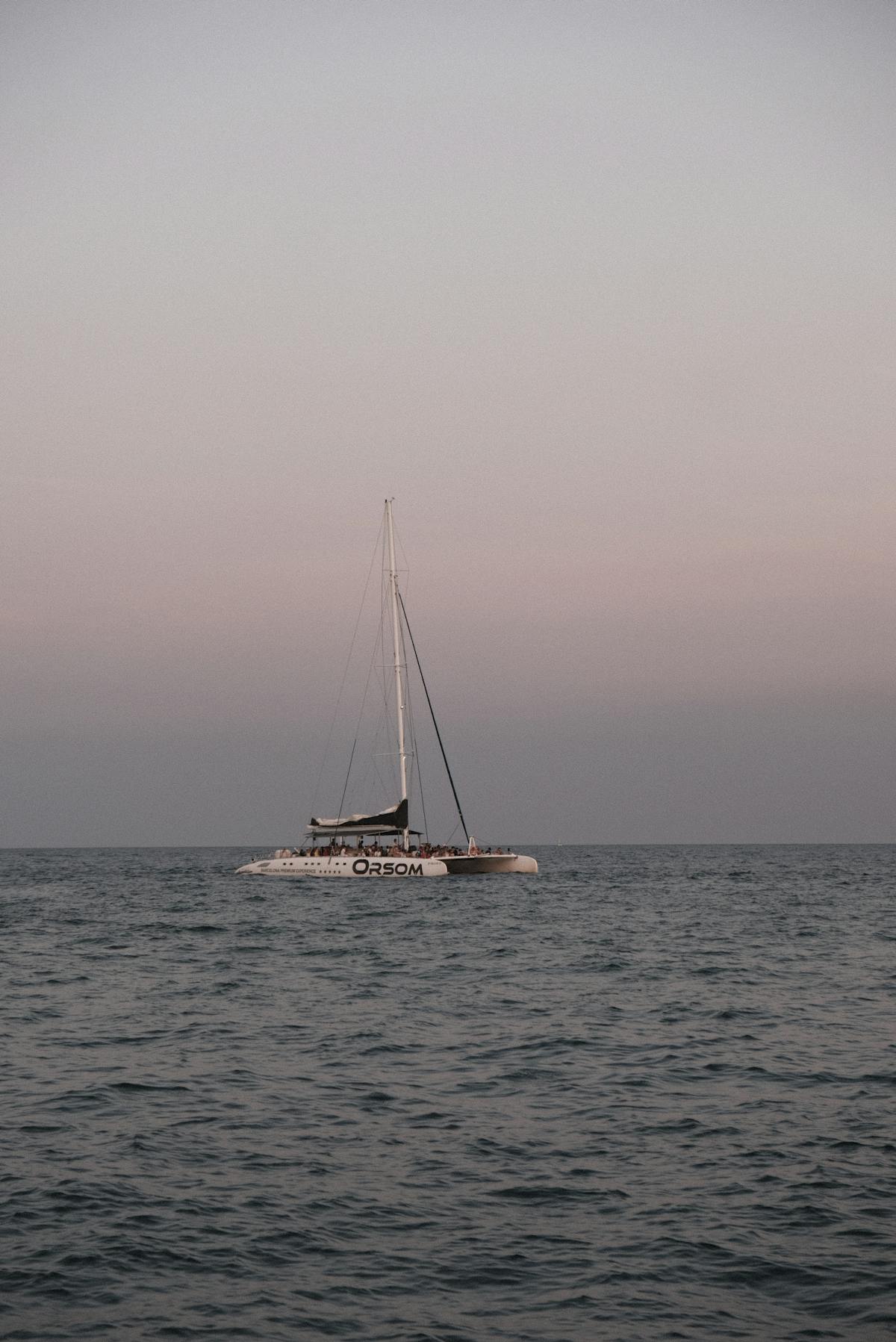 Catamaran sailing on calm Mediterranean waters at sunset