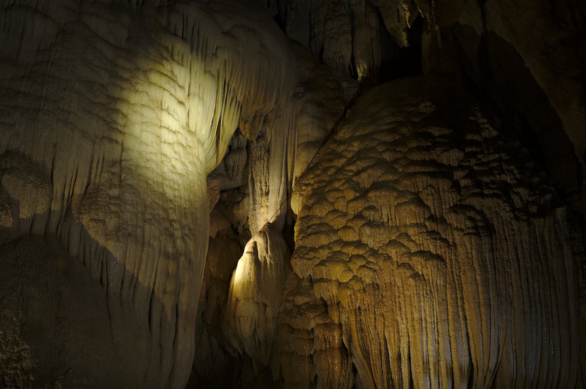 Stalactites and cave formations illuminated by natural lighting inside a cave