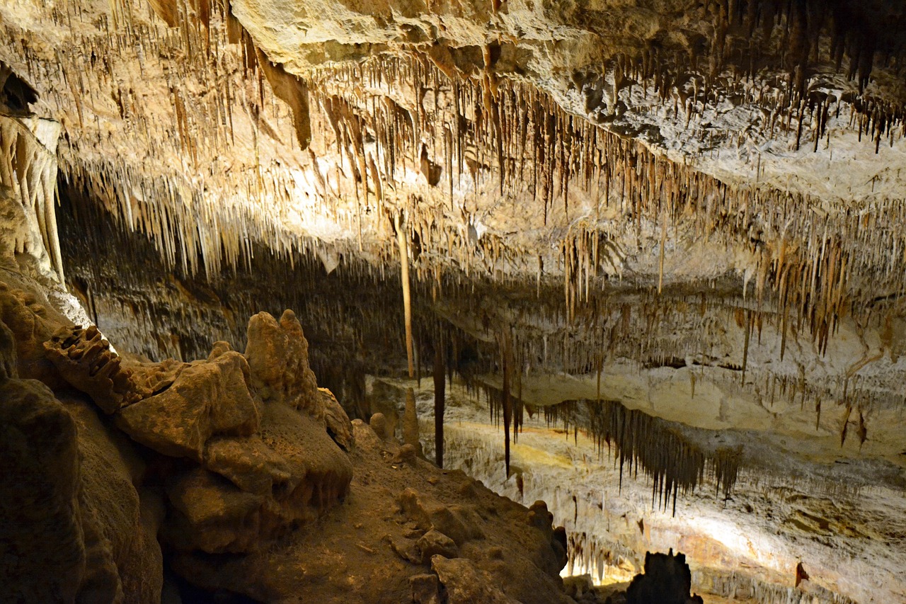 Interior of the Caves of Drach showing dramatic stalactite formations in warm lighting