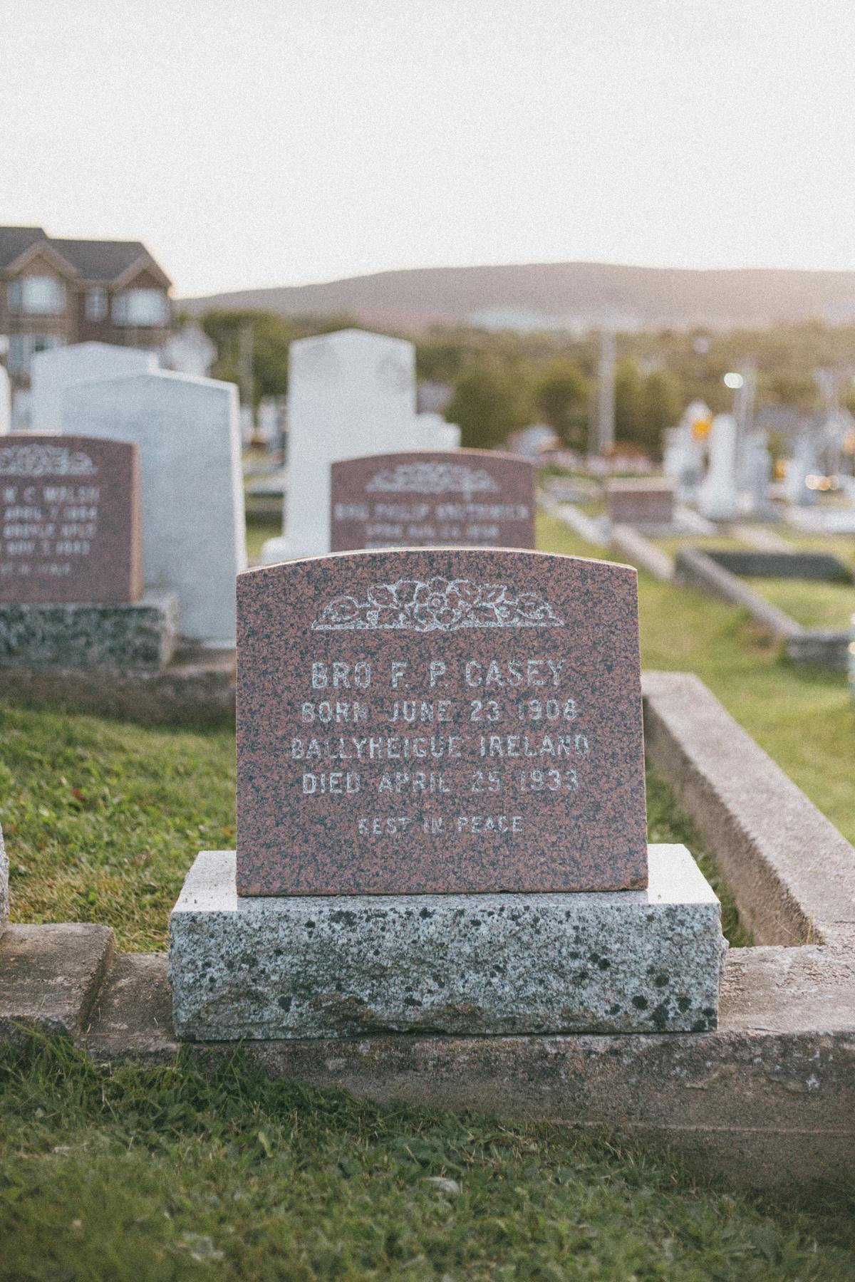Historic gravestones and monuments in a cemetery bathed in warm sunset light