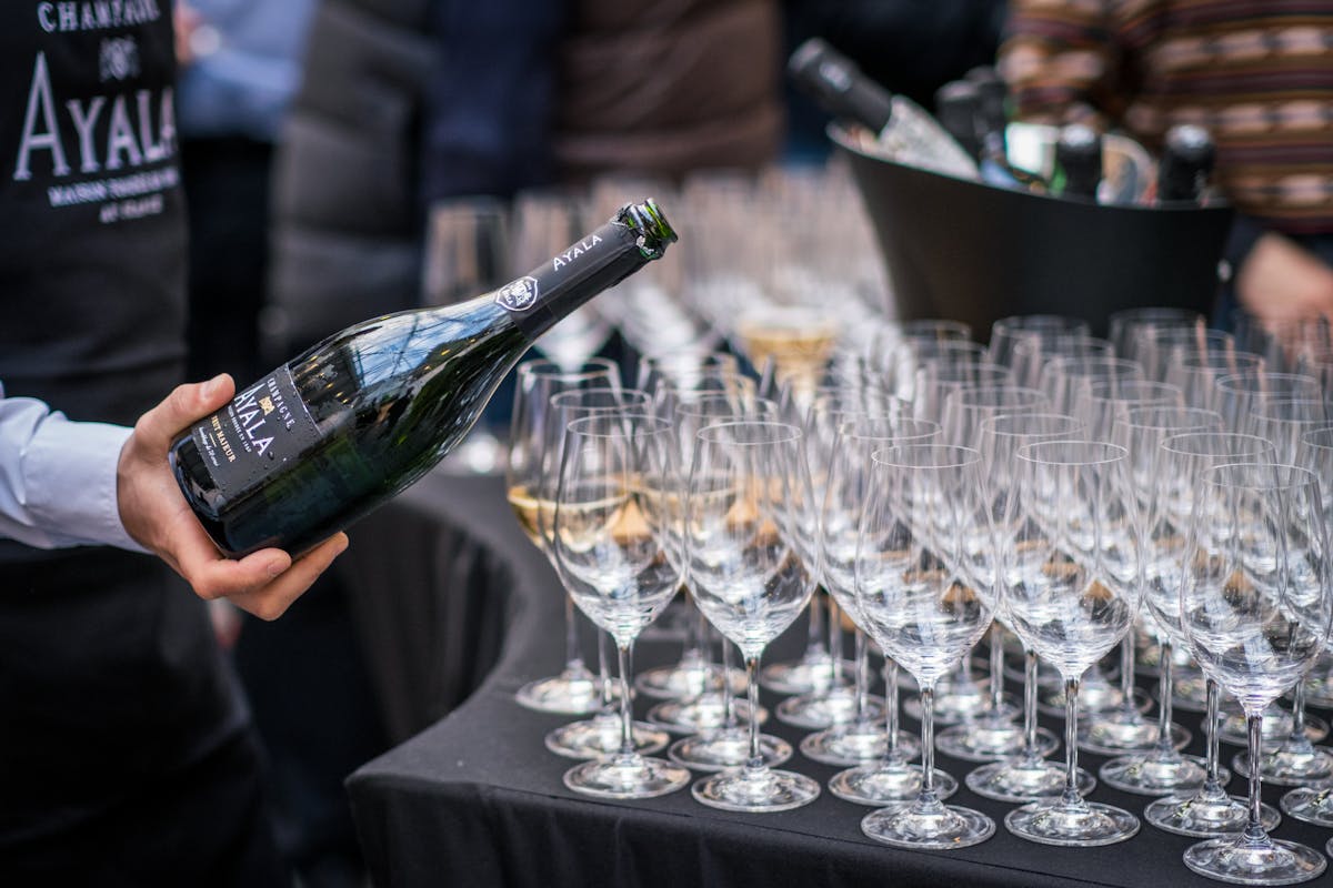 A waiter pouring champagne into glasses at a sophisticated Paris evening