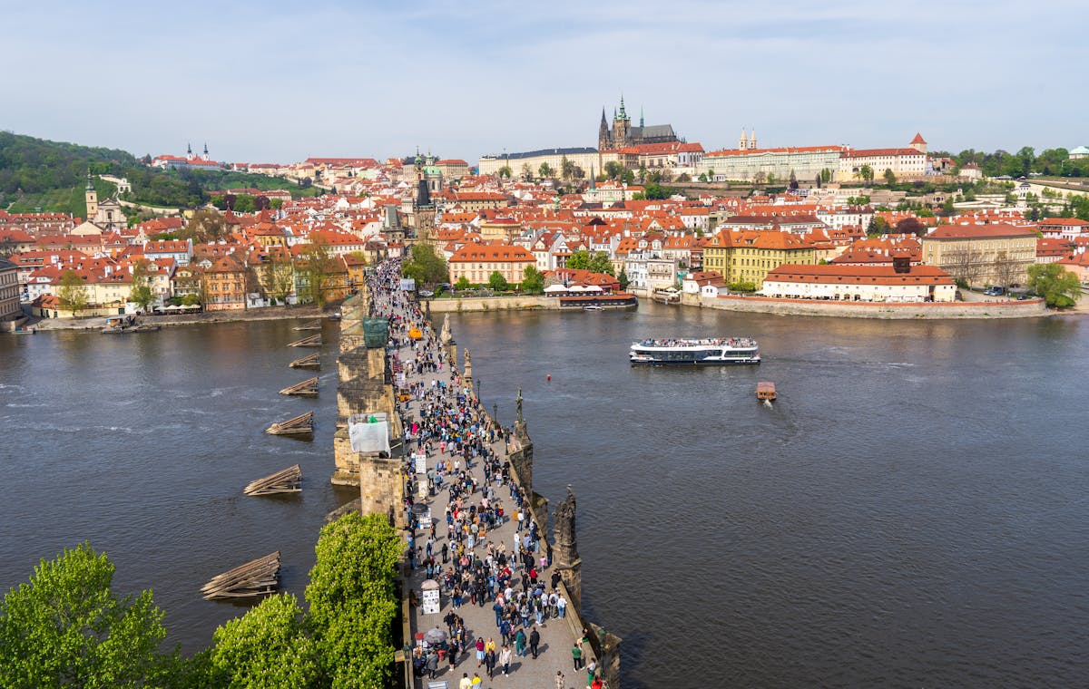 Scenic aerial view of Charles Bridge with crowds and Prague Old Town behind