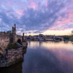 Charles Bridge and Prague skyline reflected in the Vltava River at twilight