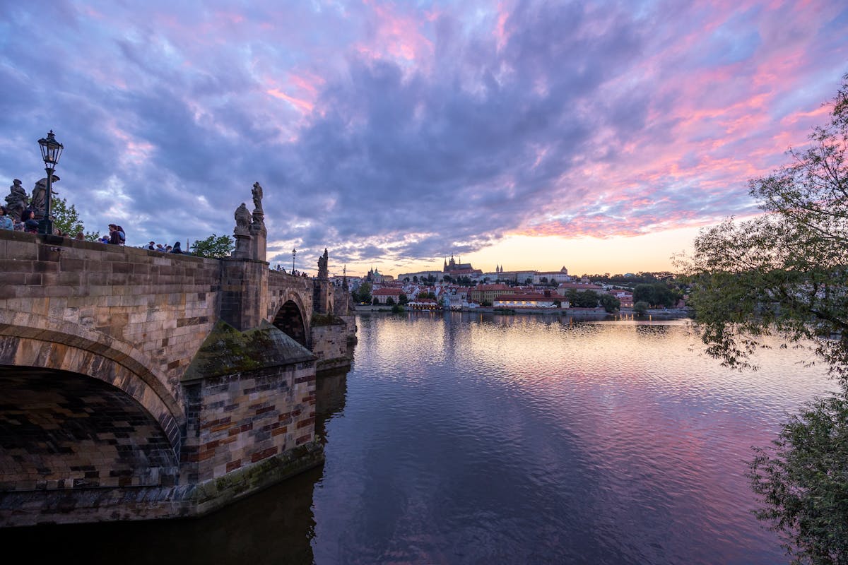 Charles Bridge and Prague skyline reflected in the Vltava River at twilight