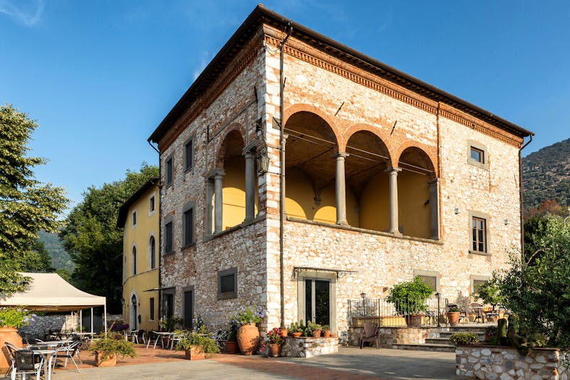 Charming stone villa in Tuscany bathed in warm sunlight with green landscape