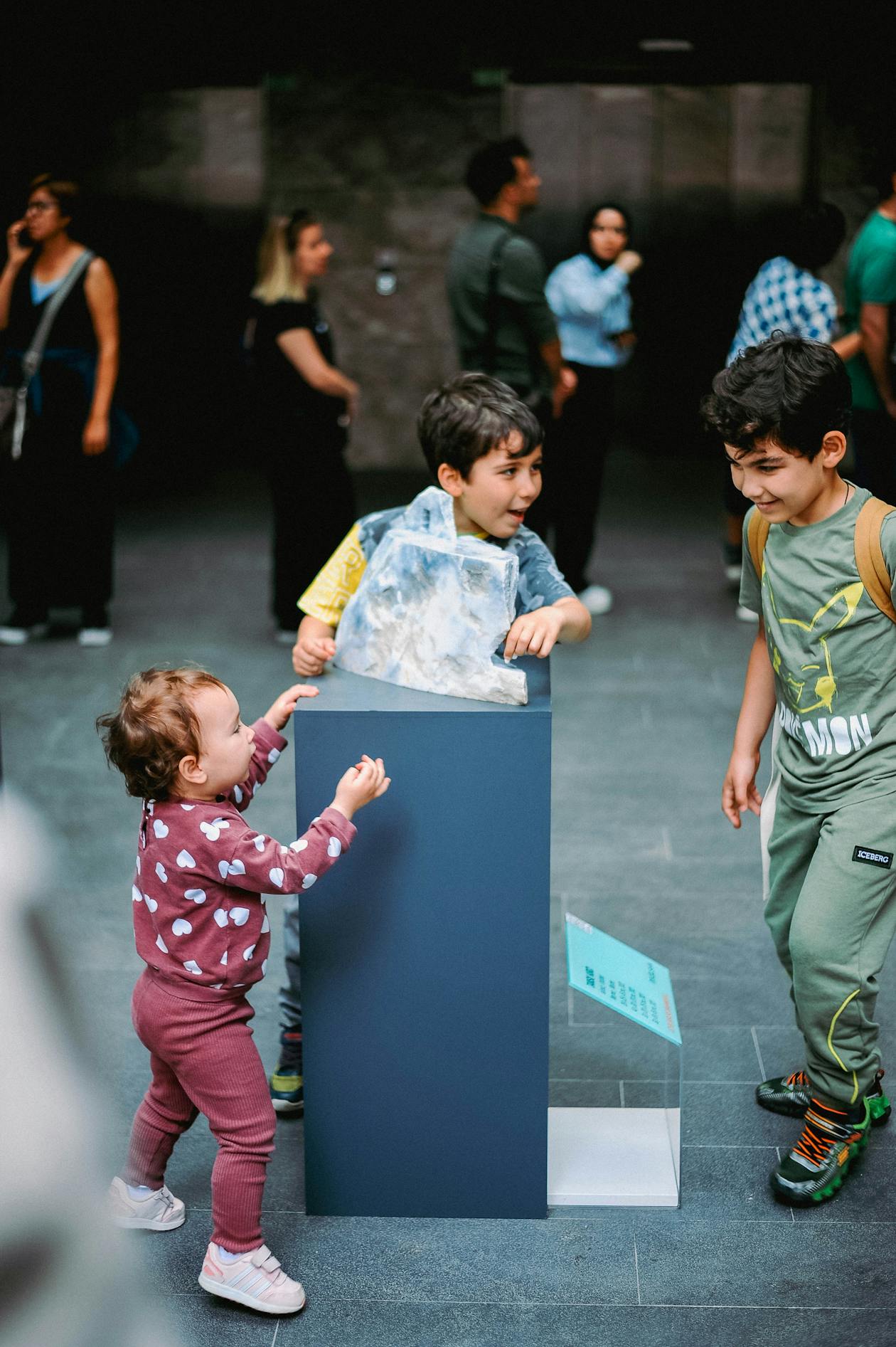 Three children excitedly exploring an exhibit in a science museum