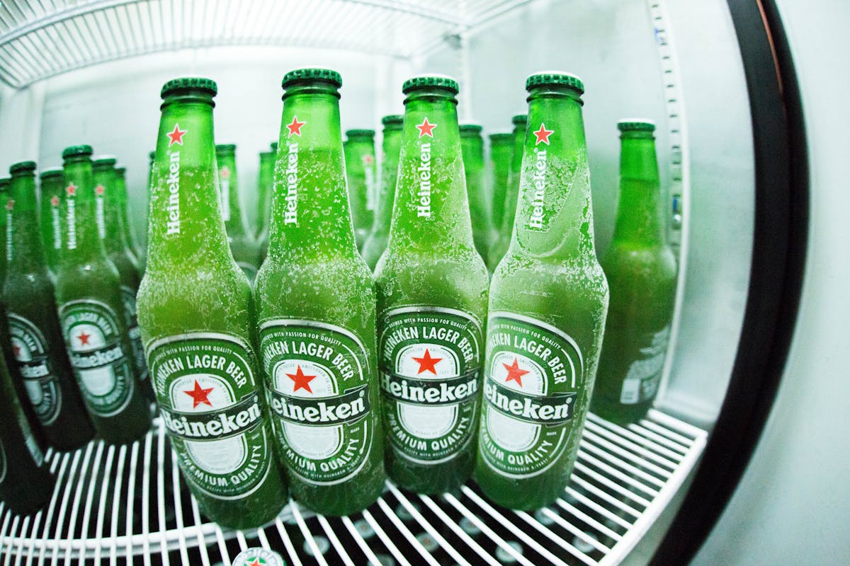 Frosted Heineken beer bottles chilling in a refrigerator