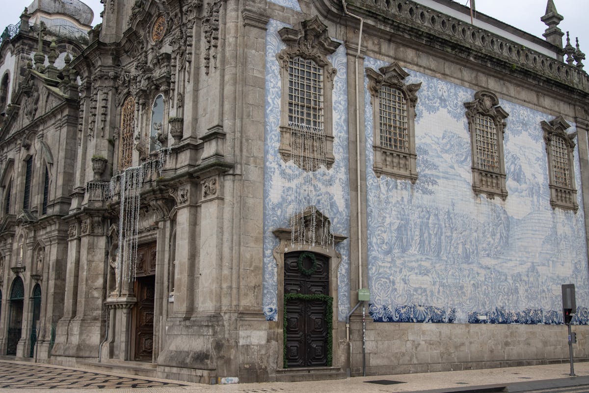 Church exterior entirely covered in traditional blue and white azulejo tiles in Porto Portugal