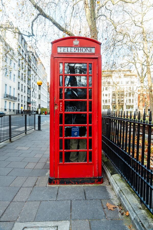Classic red telephone booth on a city street in London