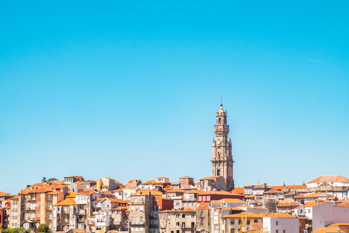 Baroque Clerigos Tower standing tall above the Porto Portugal cityscape under blue sky