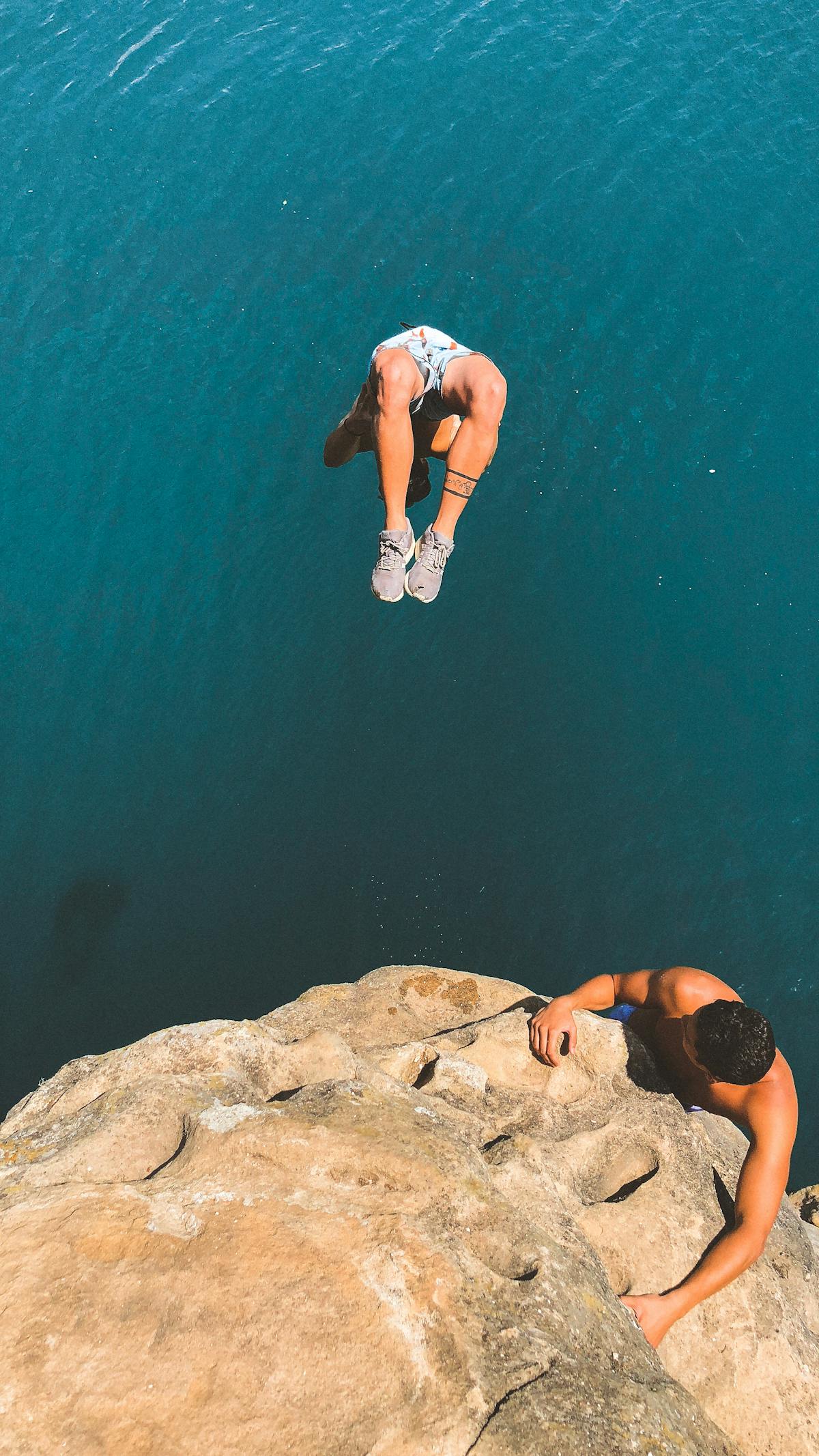 Group cliff diving scene in scenic coastal waters
