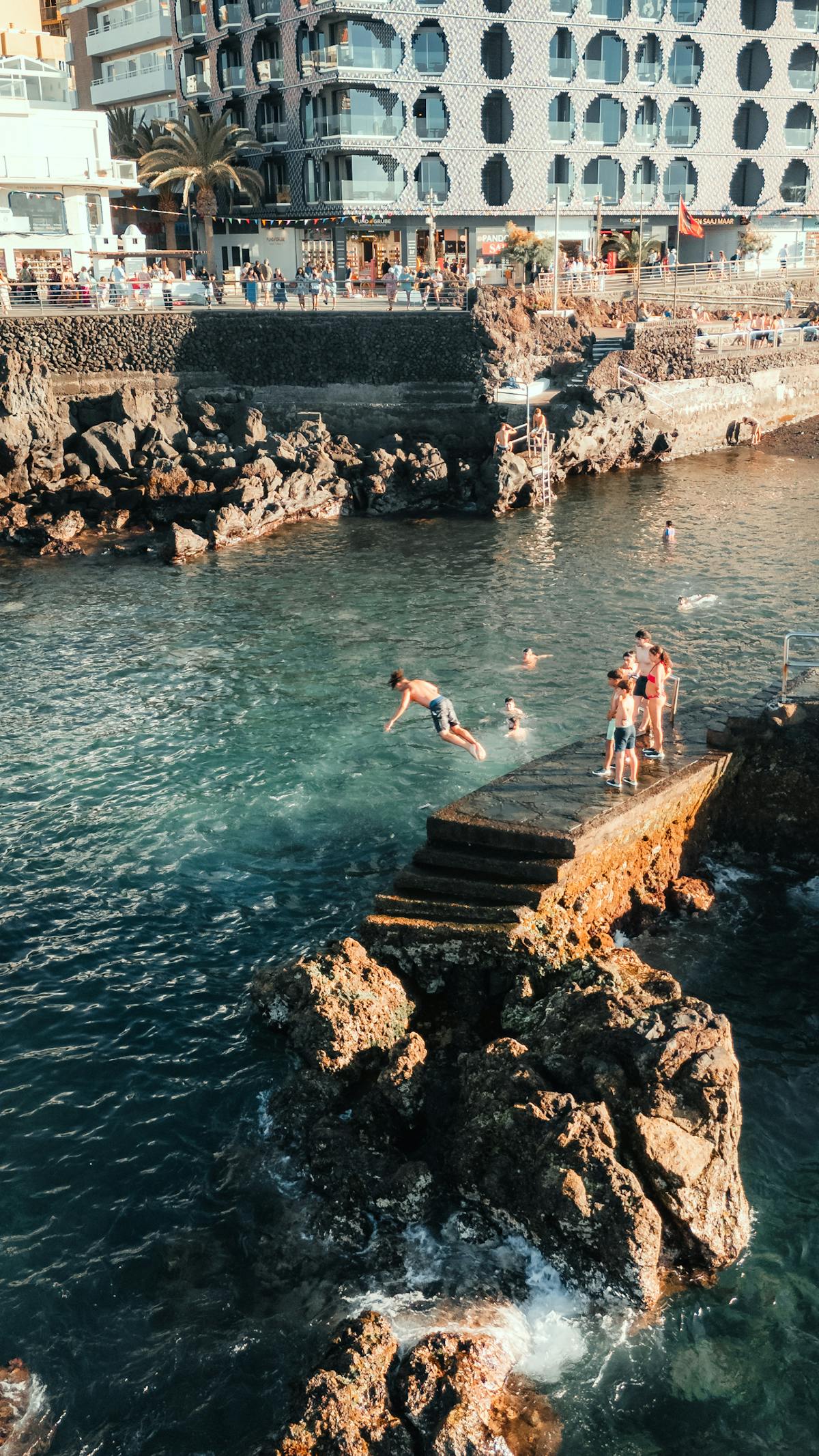 Adventurous cliff jumping into turquoise coastal waters
