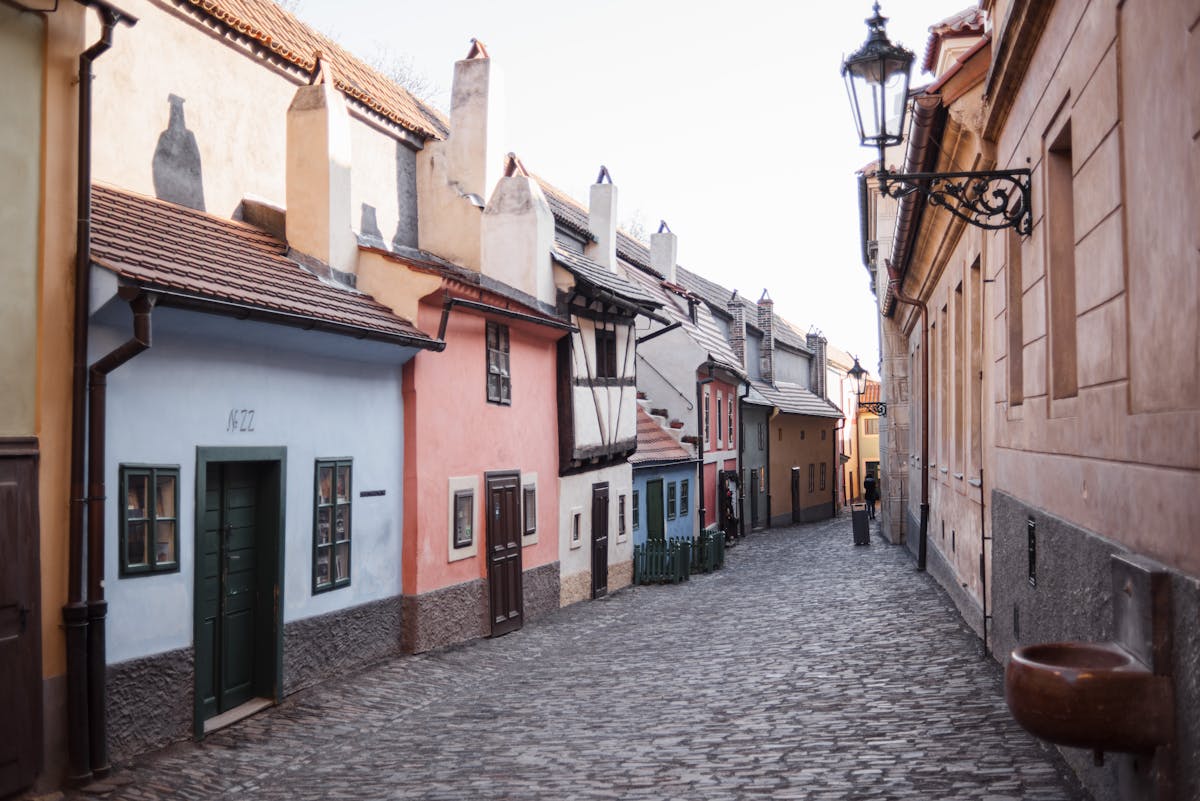 Rough cobblestone walkway between aged residential building facades in Prague