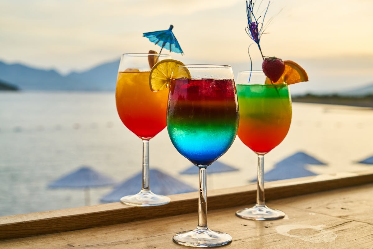 Colorful cocktails with garnishes at a sunset setting