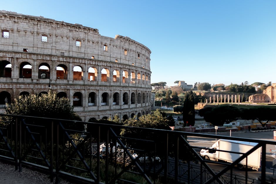 The Colosseum with the Roman Forum visible in the foreground on a sunny day